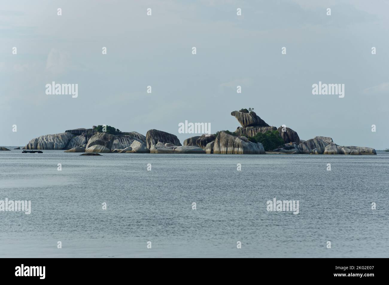 A stone island in Belitung (Pulau Burung) in the calm Java sea ...