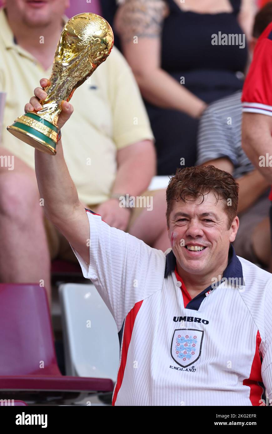 Doha, Qatar. 21st Nov, 2022. An England fan holds up a replica World ...