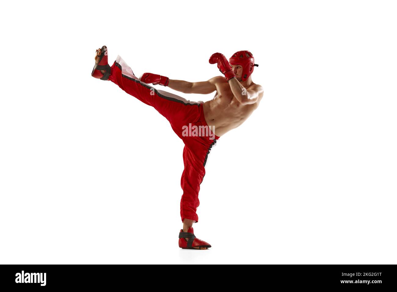 Young professional kickboxer wearing helmet and boxing gloves in motion ...