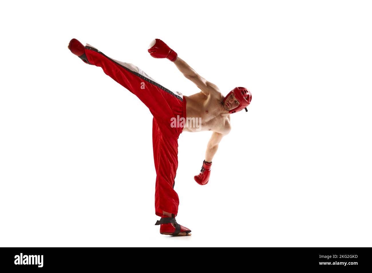Leg kick. Young professional kickboxer wearing helmet and boxing gloves ...