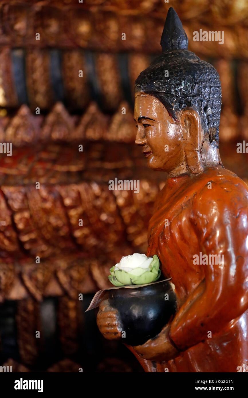 Wat Phnom Daun Penh buddhist temple. Buddha statue with offerings ...