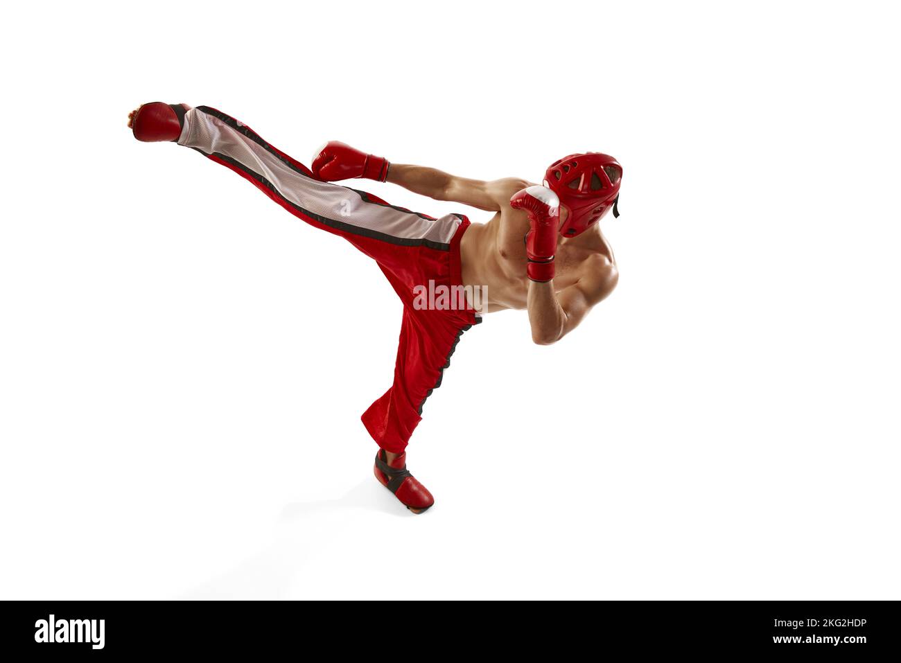 Young professional kickboxer wearing helmet and boxing gloves in motion ...