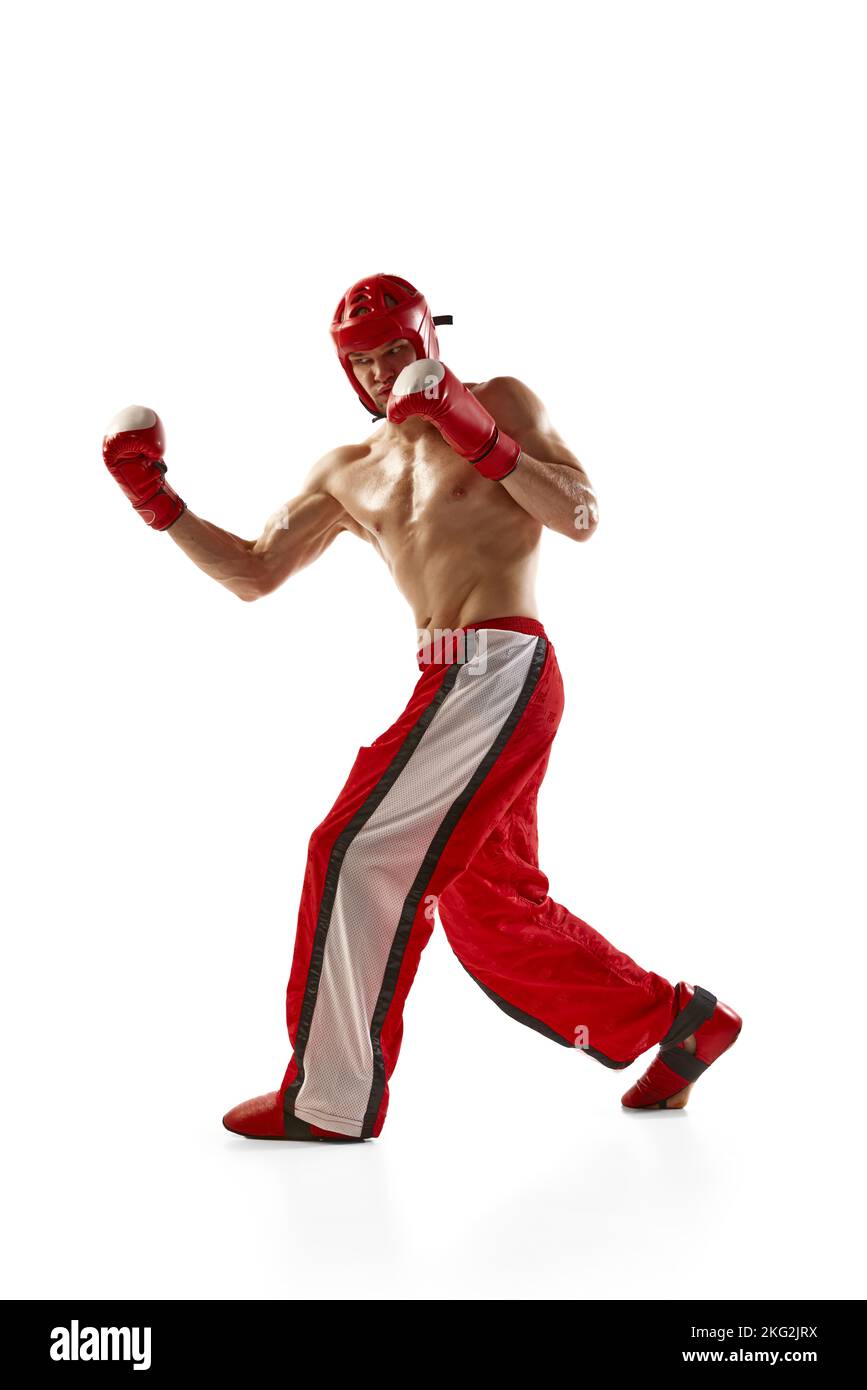 Punch. Young muscled athlete, professional kickboxer in protective ...