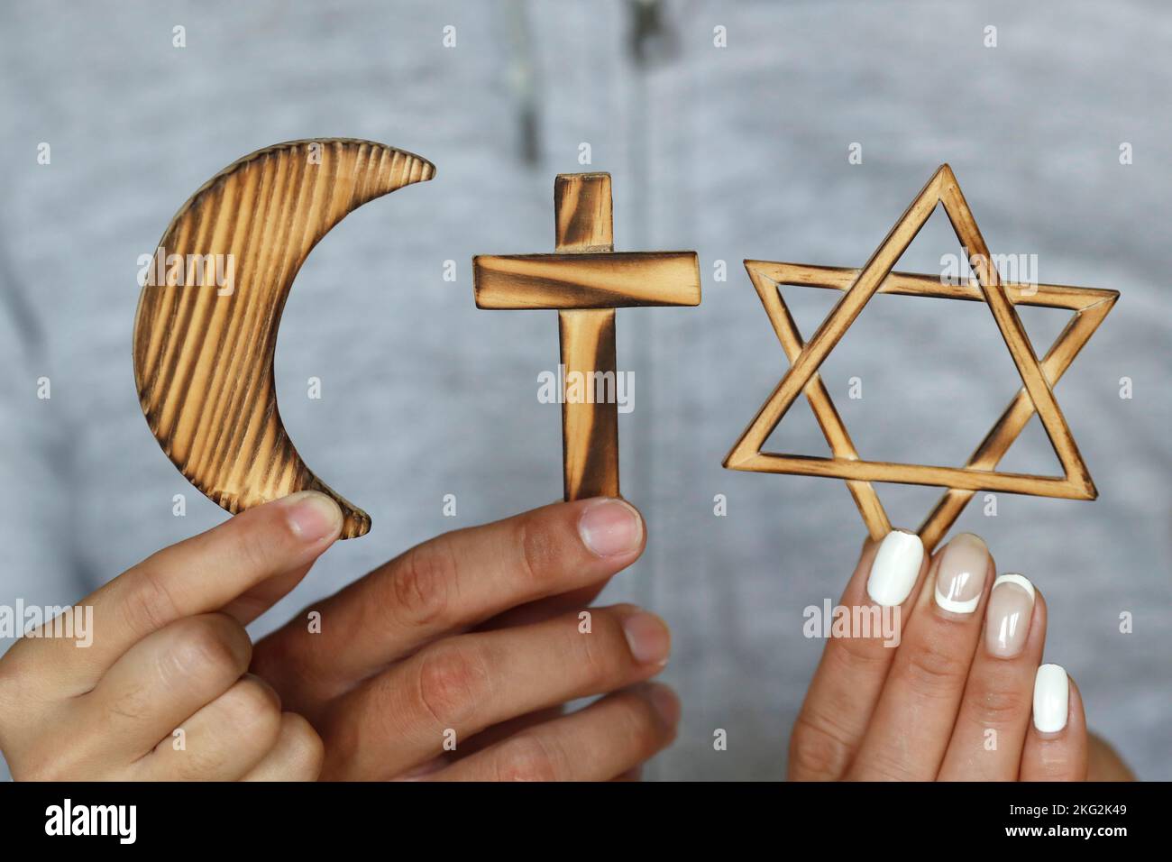 Religious symbols in three hands. Jewish Star of David, Muslim star and ...