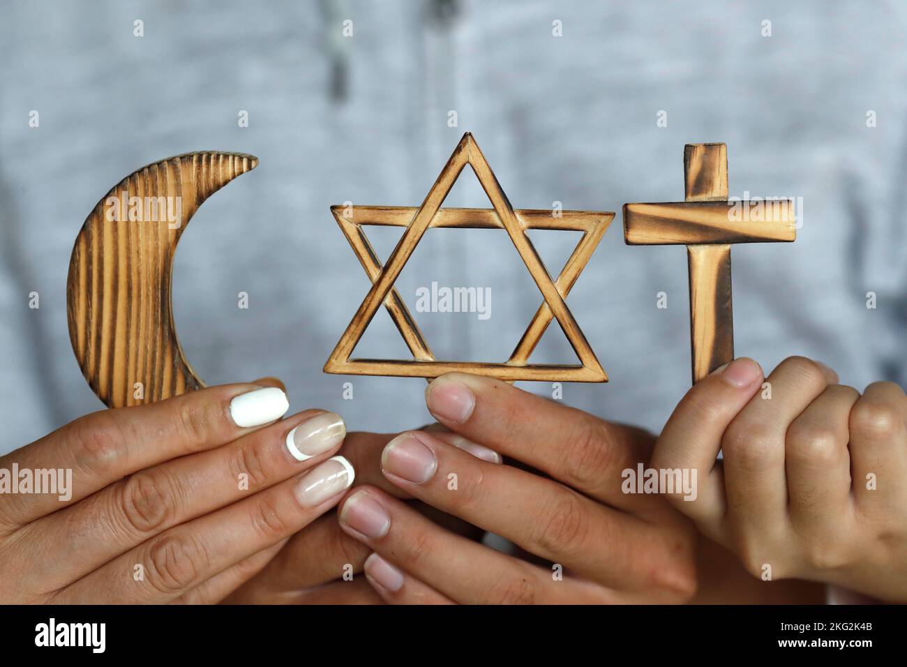 Religious symbols in three hands. Jewish Star of David, Muslim star and ...