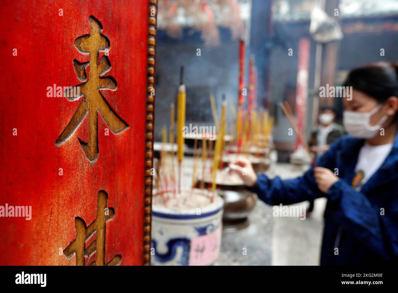Ba Thien Hau Chinese Temple. Buddhist woman praying with incense sticks ...