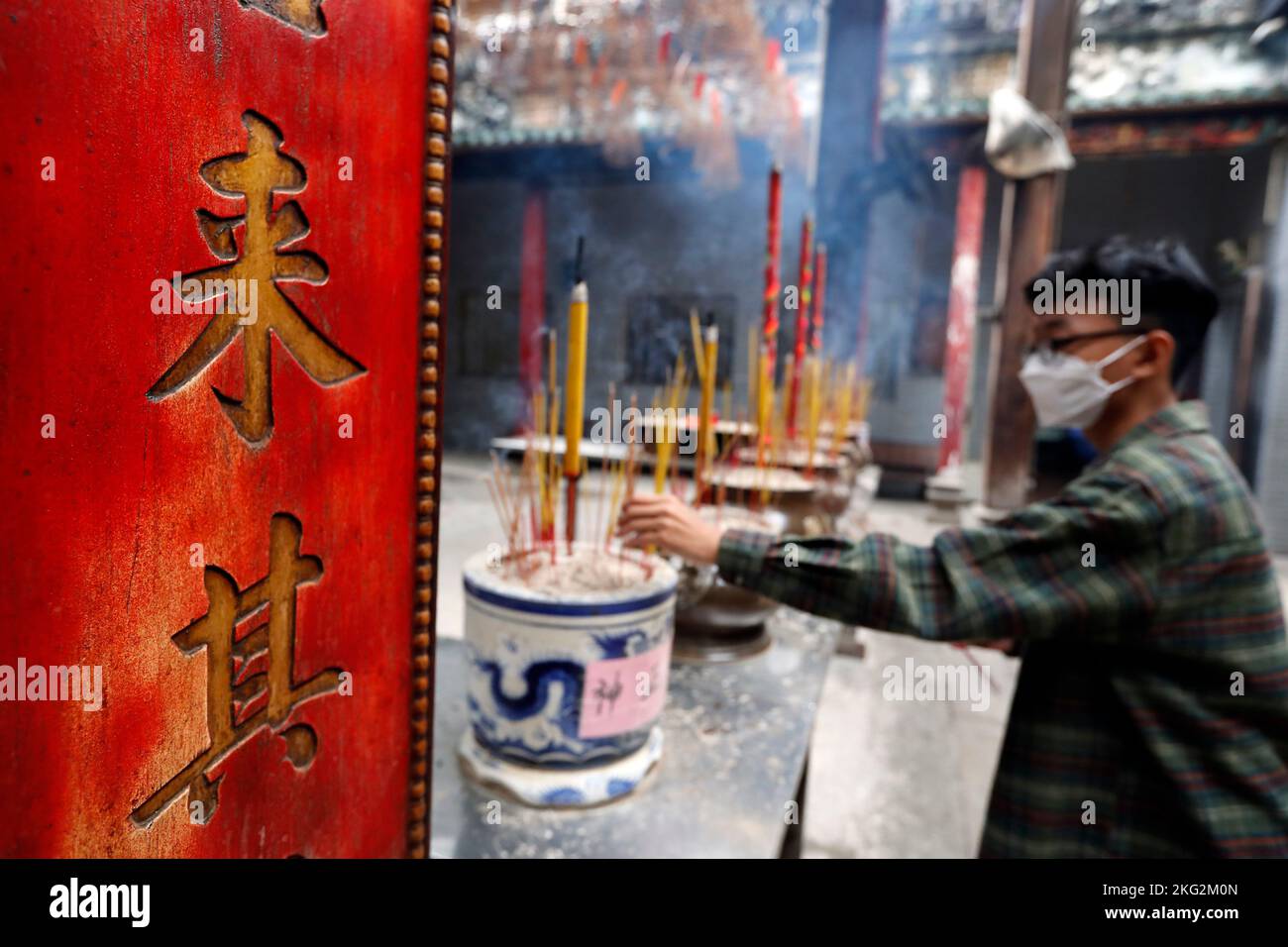 Ba Thien Hau Chinese Temple. Young man praying with incense sticks ...