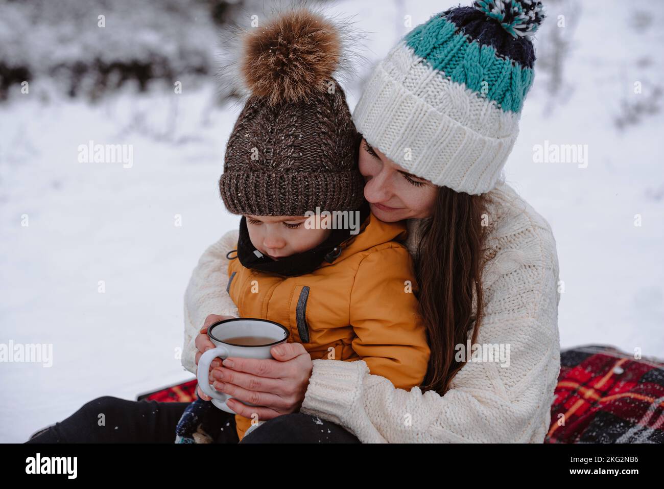 Mother and child son daughter on a winter walk outdoors drinking tea ...