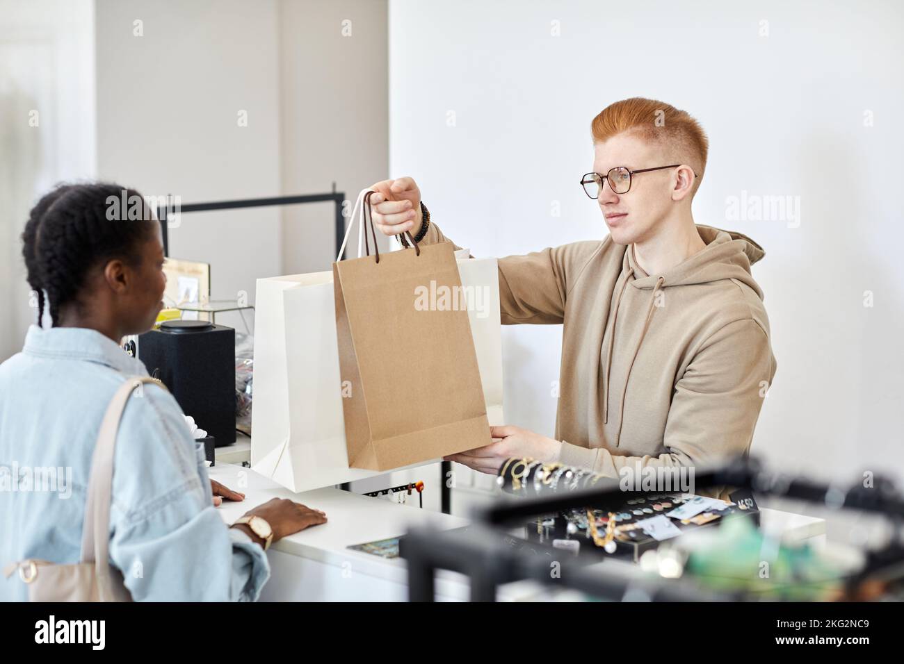 Clerk handing over shopping bag hi-res stock photography and images - Alamy