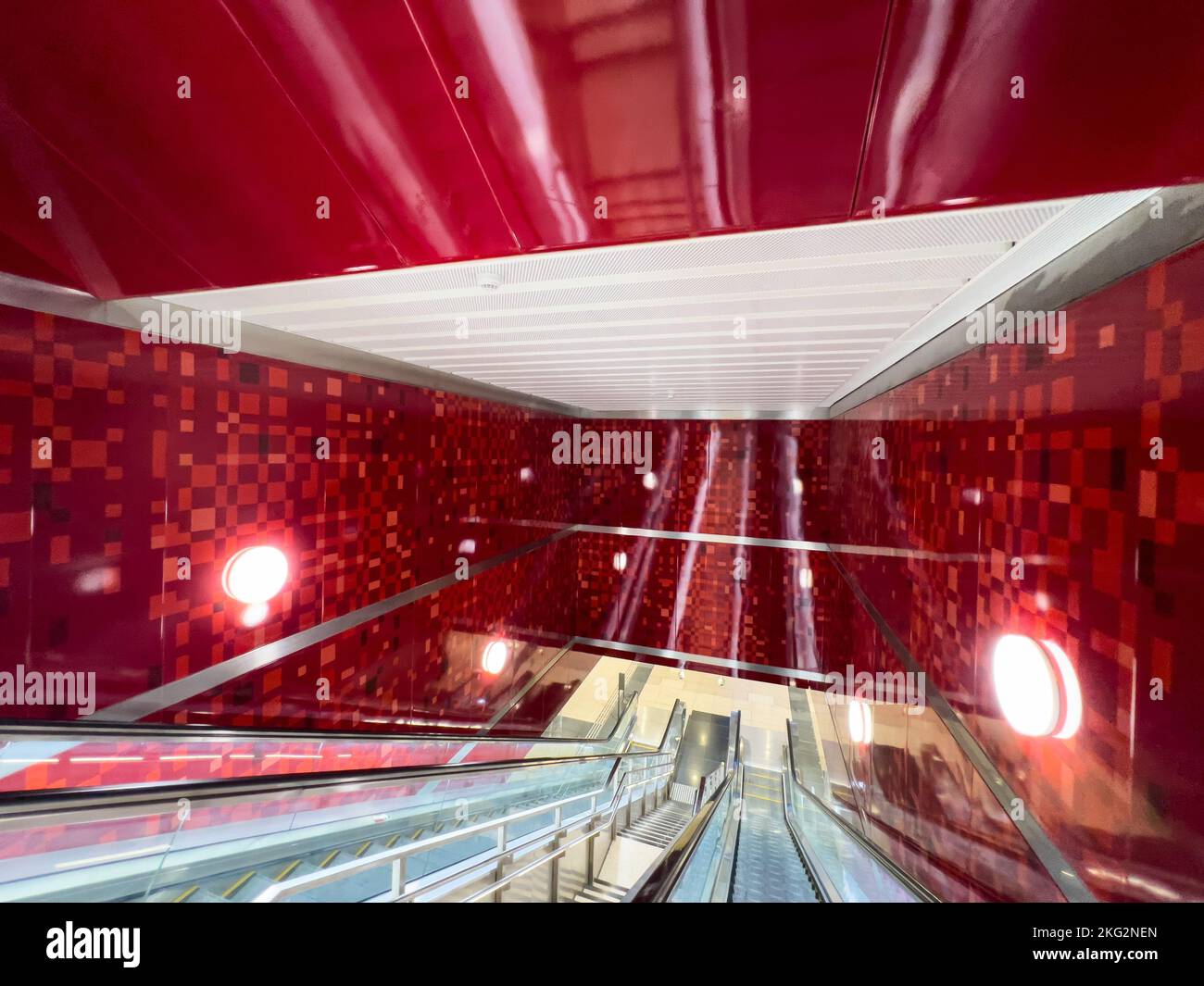 Inside an underground train station. A long escalator travel deep down ...