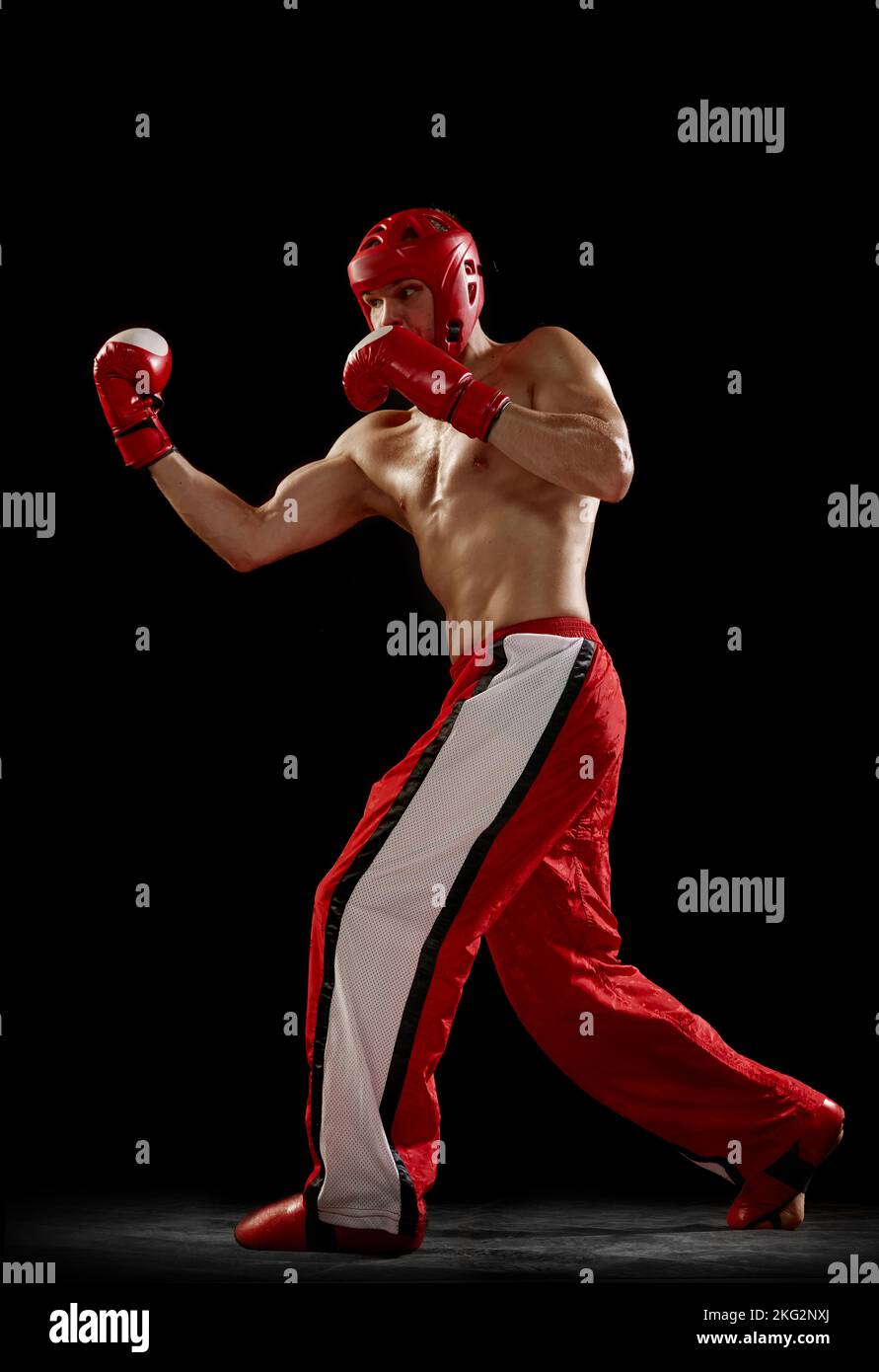 Studio shot of male kickboxer, mma fighter in motion and action ...