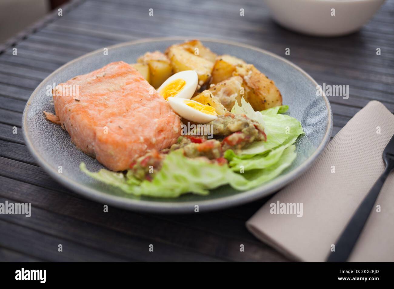 steamed salmon fillet with potato wedges, guacamole homemade and quail ...