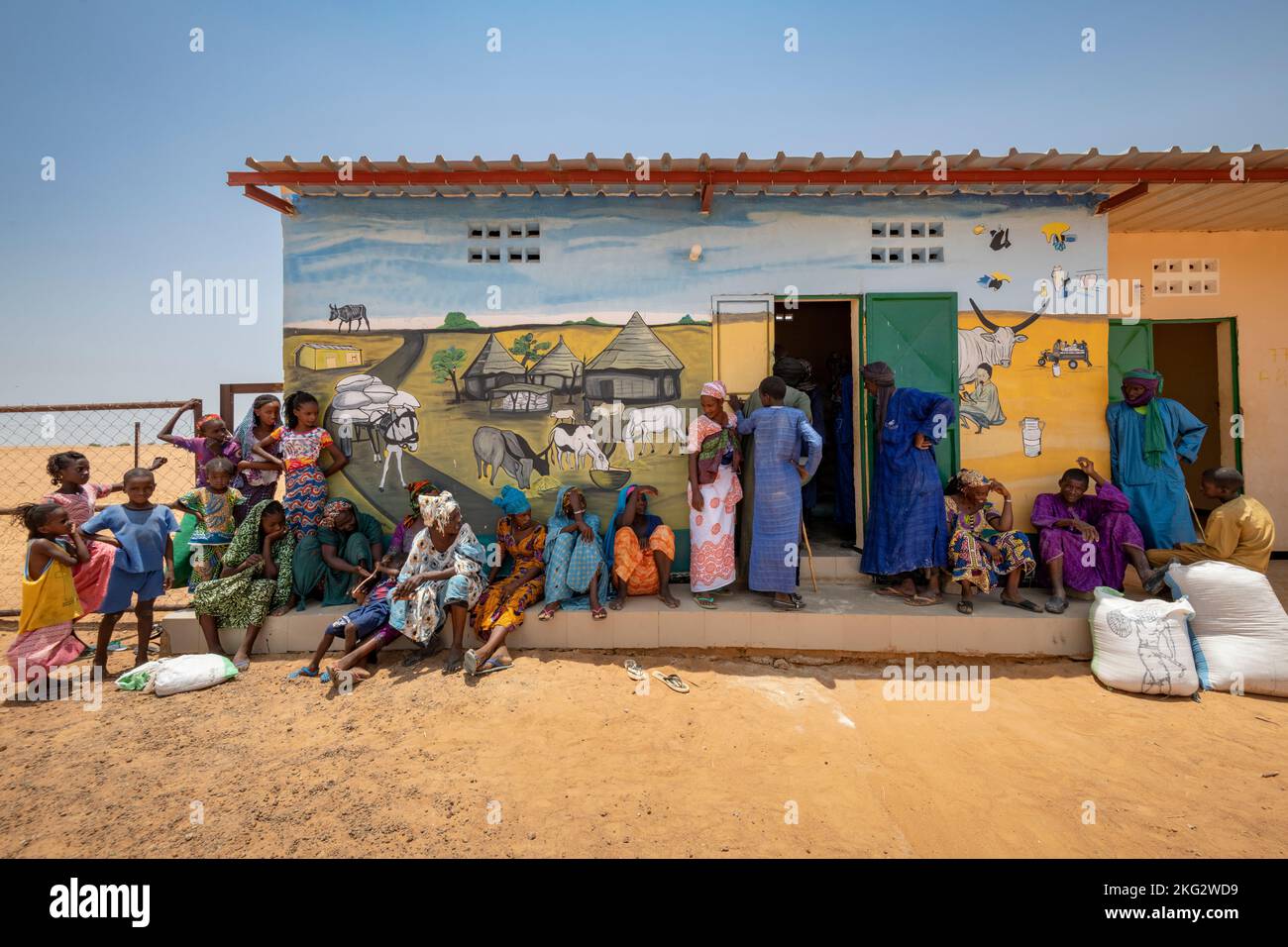 Herders standing and sitting outside at the livestock food warehouse in ...