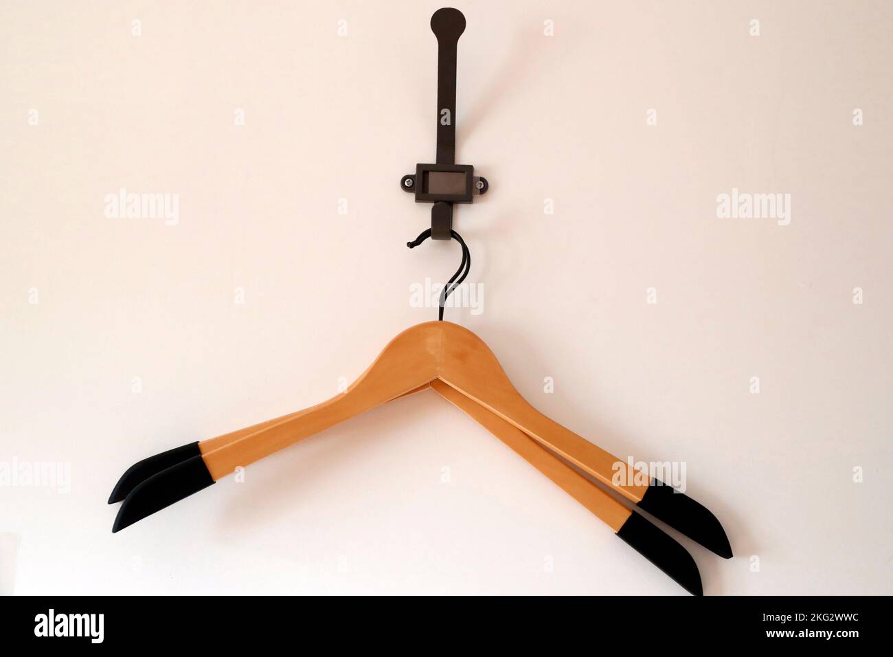 Closeup of two empty wooden hangers hanging from a hook Stock Photo - Alamy