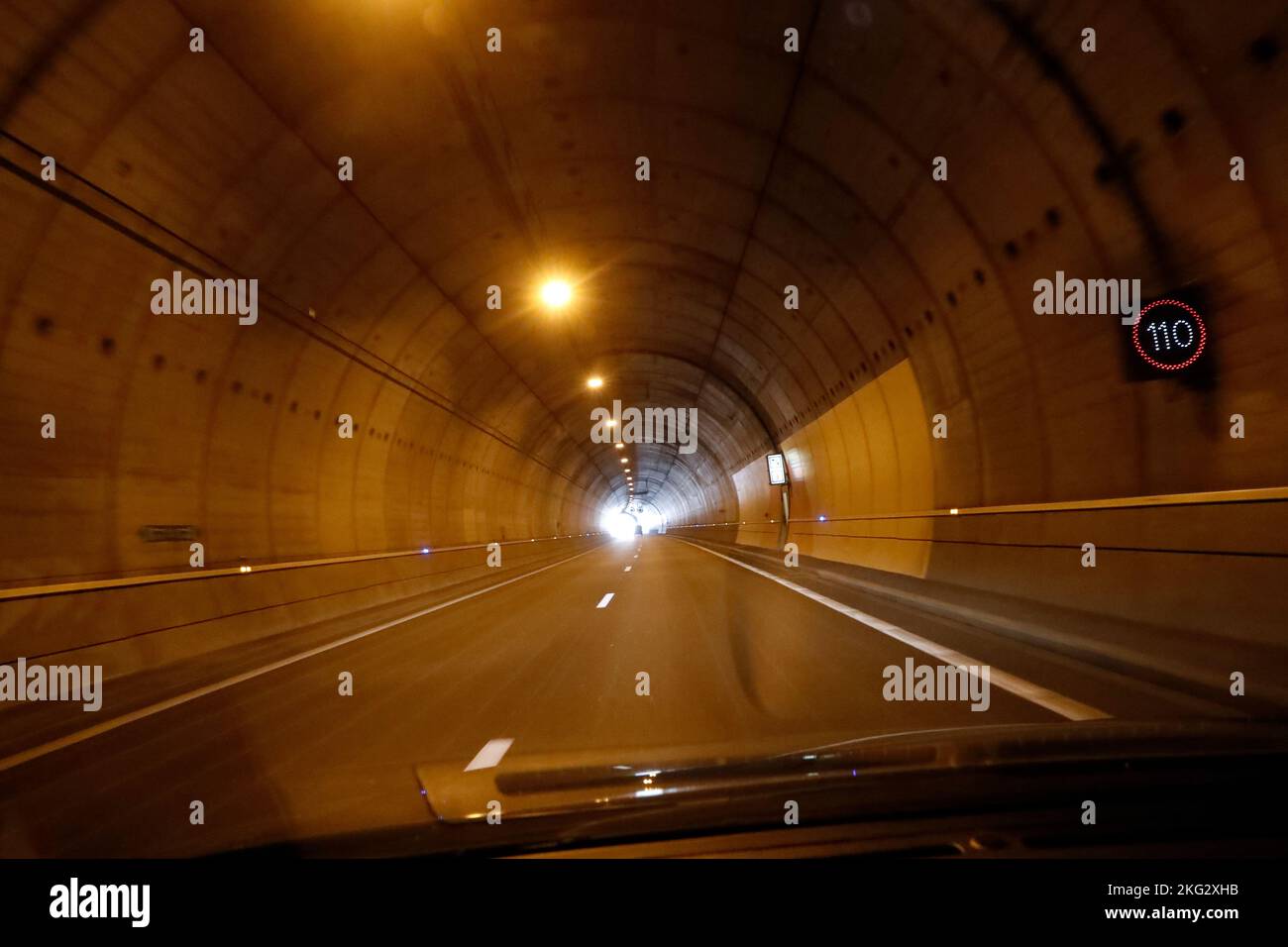 Car driving through a tunnel in the French alps with speed limit ...