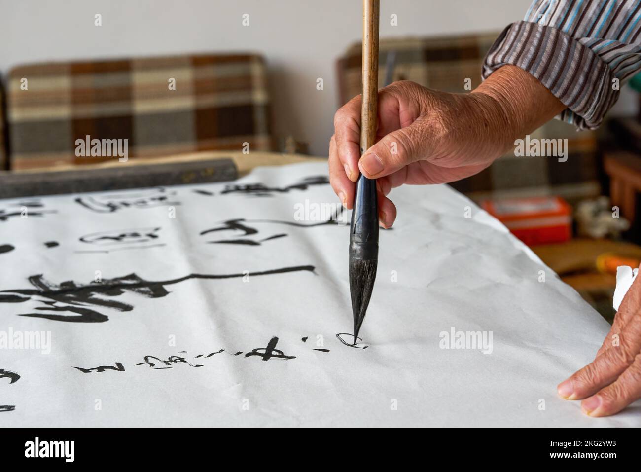 An old Chinese calligrapher is writing calligraphy characters, creating ...