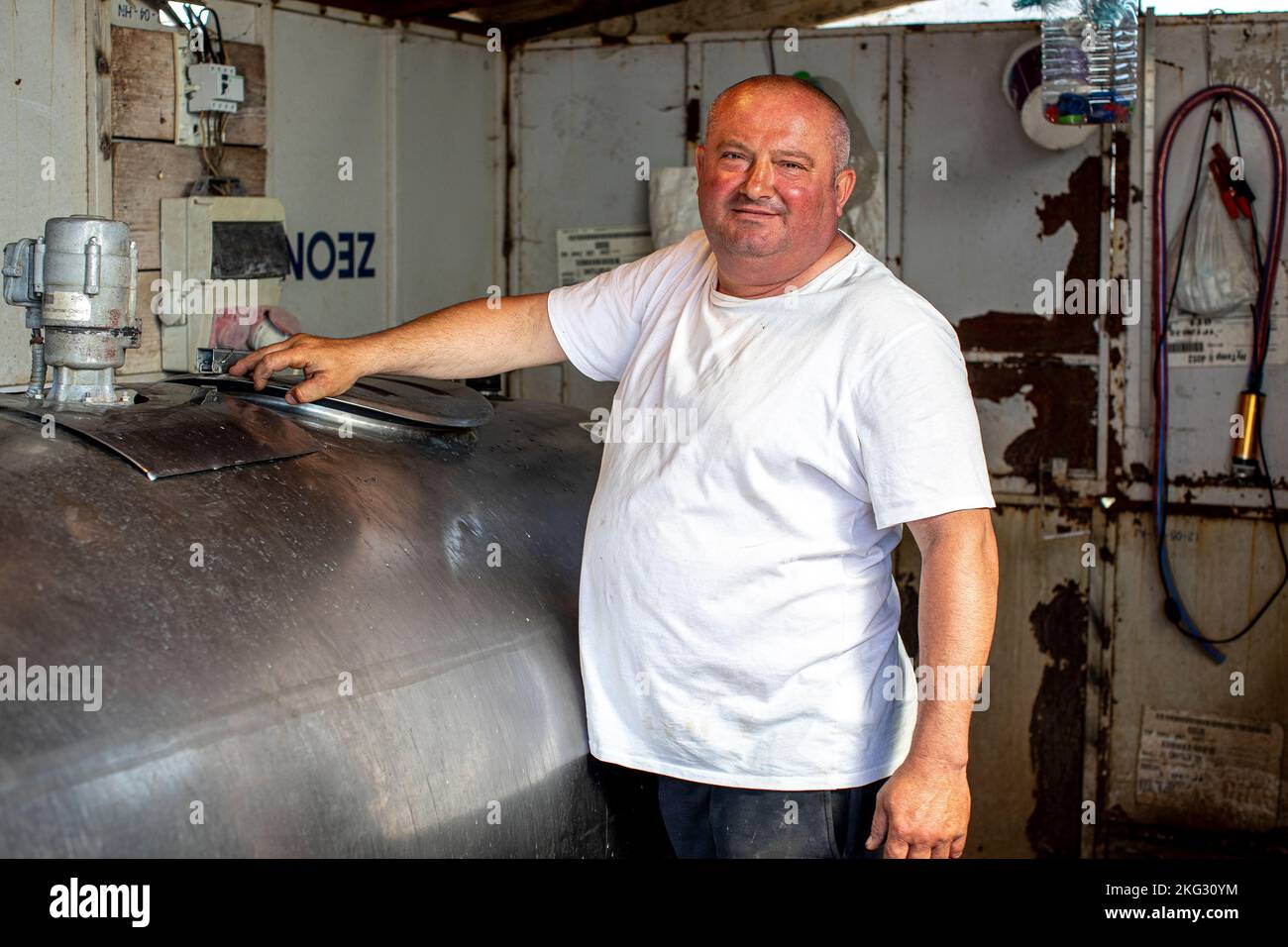 Dairy farmer opening his fresh milk container in Timis province ...