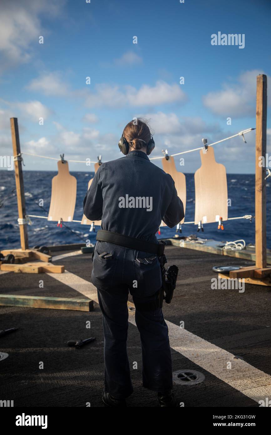 A U.S. Sailor fires an M9 pistol aboard the Guided-Missel Destroyer U.S ...