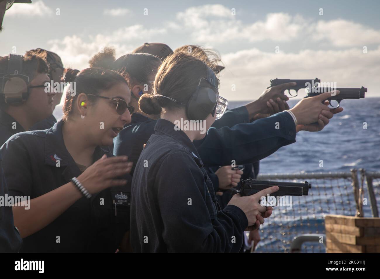 A U.S. Sailor fires an M9 pistol aboard the Guided-Missel Destroyer USS ...