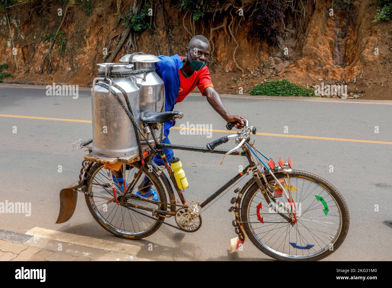 Man pushing a bike loaded with milk containers in Kigali, Rwanda Stock ...