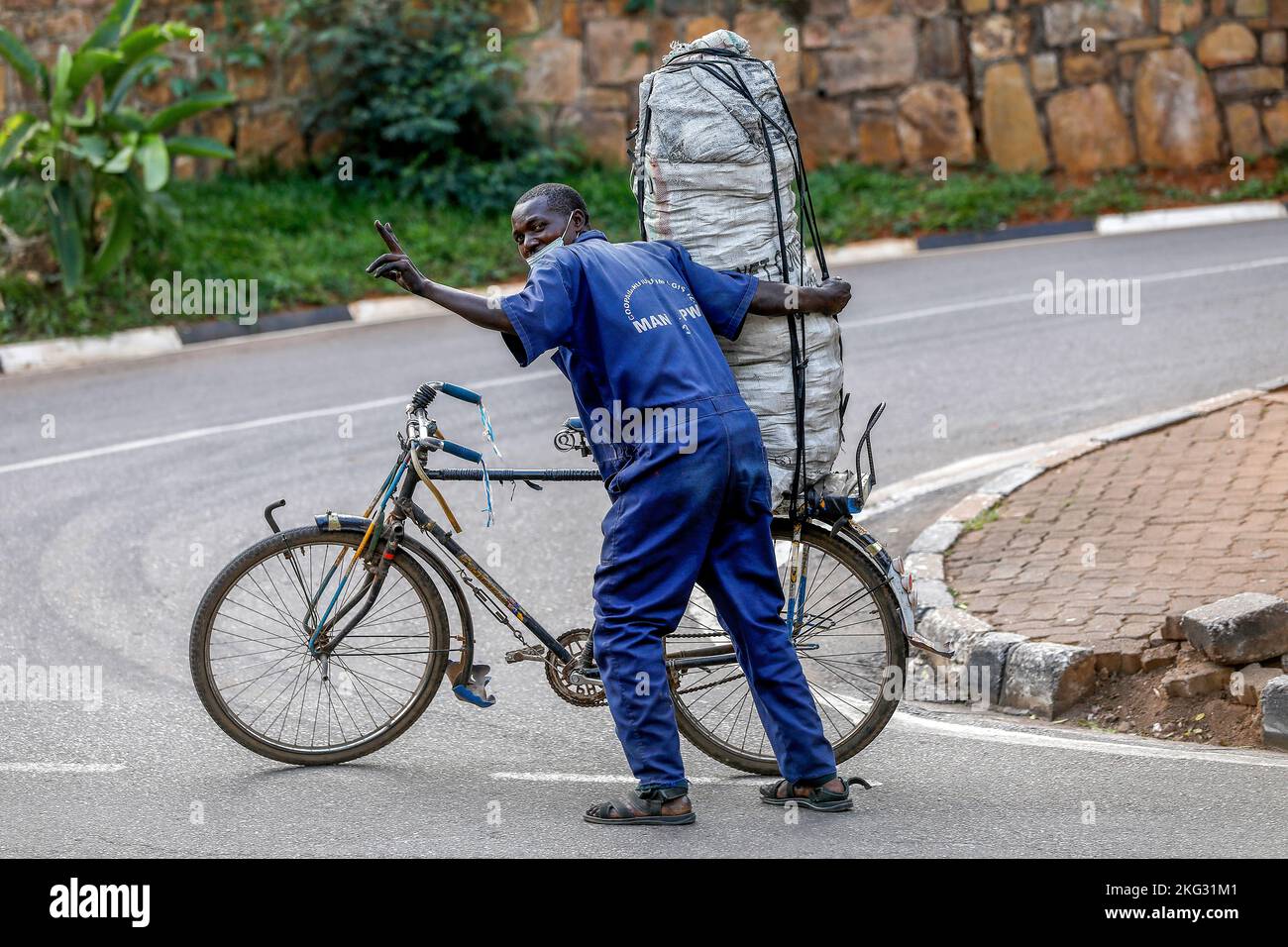Man pushing a bike loaded with a big bag in Kigali, Rwanda Stock Photo ...