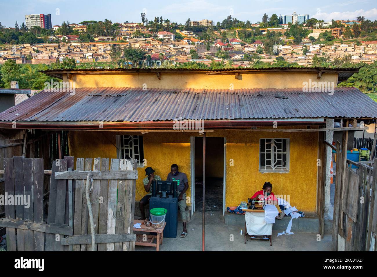 Rwandans sitting outside their home and doing various activities in ...