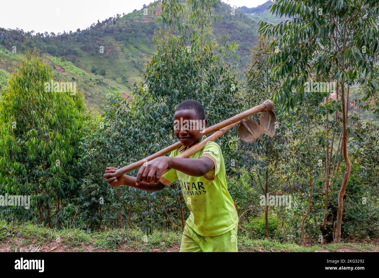 Boy carrying tools in Northern Rwanda Stock Photo - Alamy