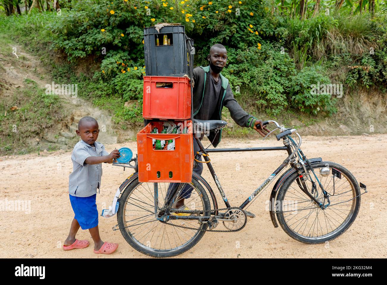 Man and boy pushing a bike loaded with crates in western Rwanda Stock ...