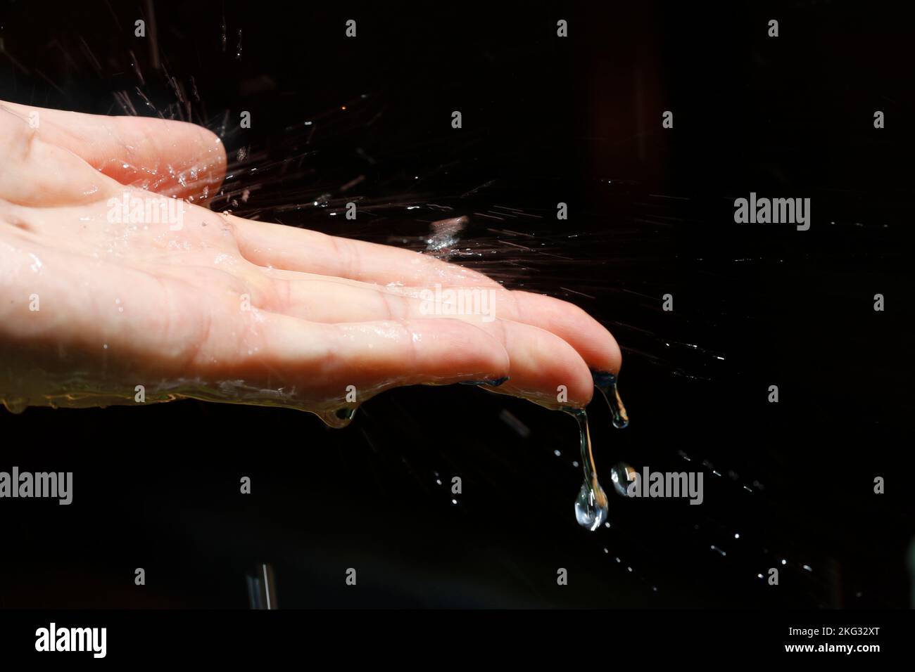 Close up of women's hand in the rain. Raindrops fall into her hand ...
