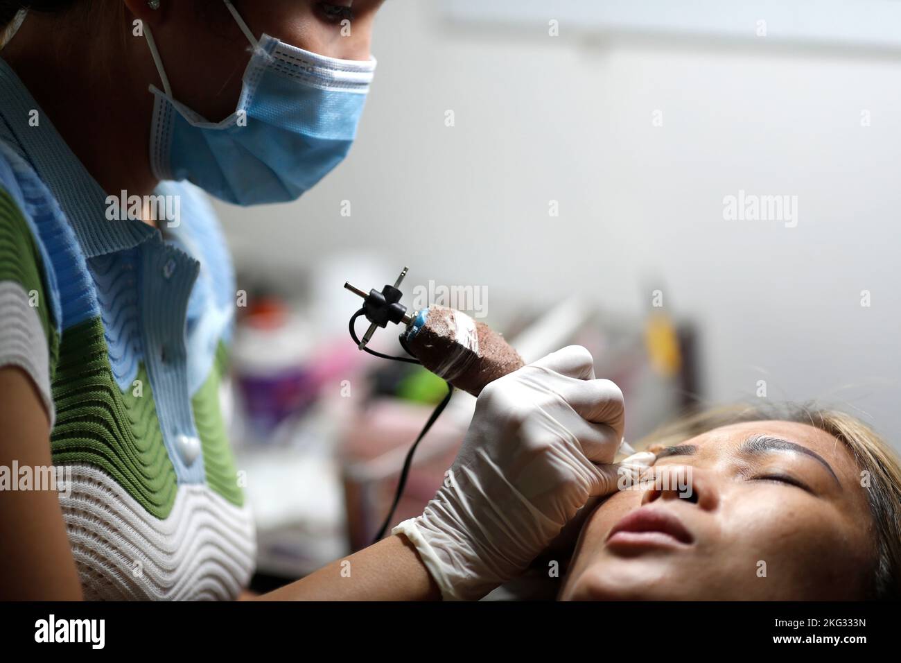 Cosmetology cabinet and beauty treatment. Beautician applies permanent ...