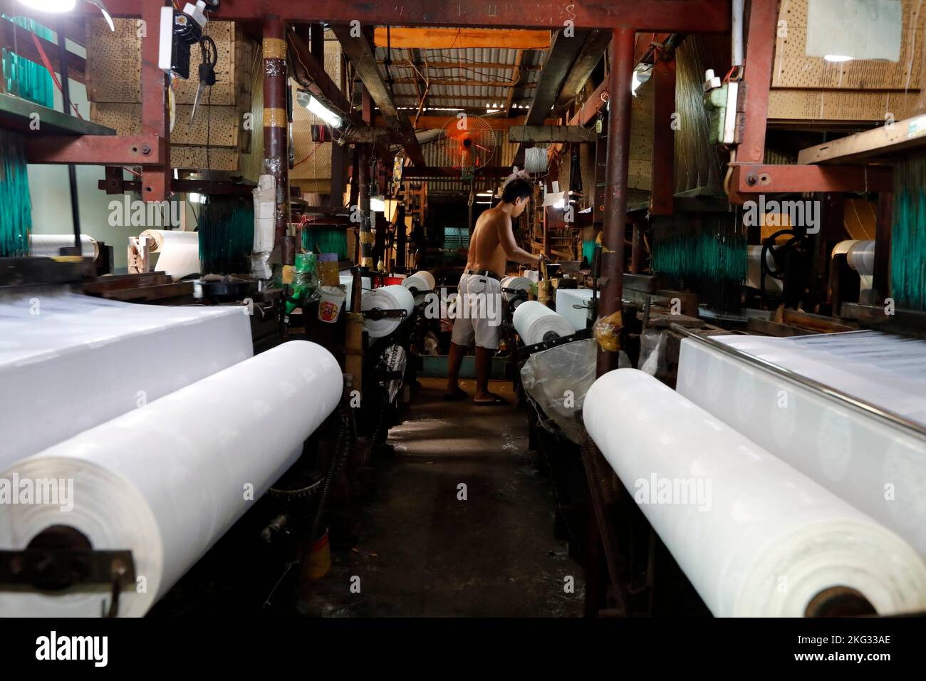 A traditional silk factory. Man working on an old silk loom. Tan Chau ...