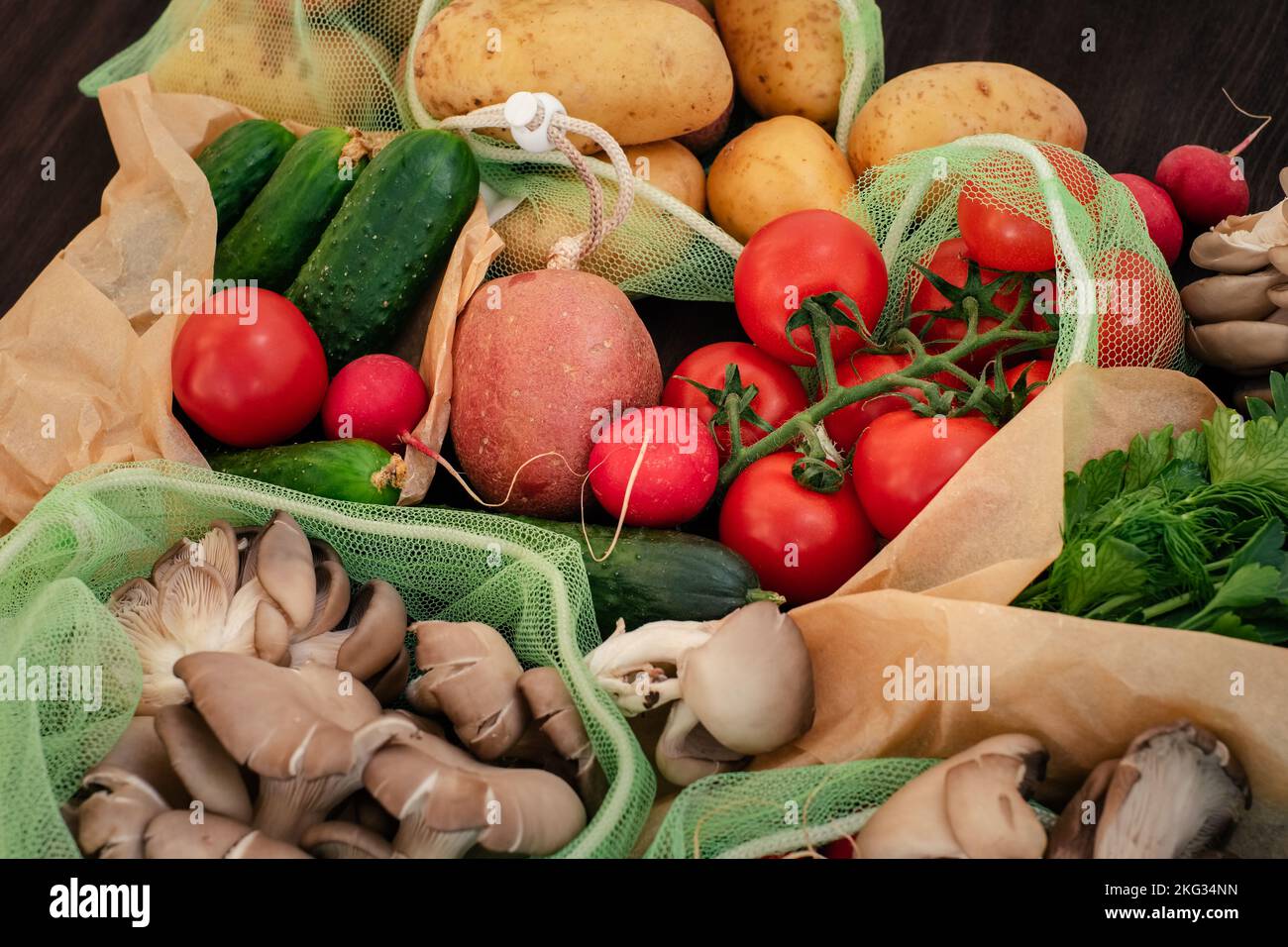 Vegetables in reusable net bags on grey wooden background, top view ...