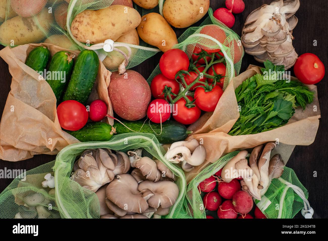 Vegetables in reusable net bags on grey wooden background, top view ...