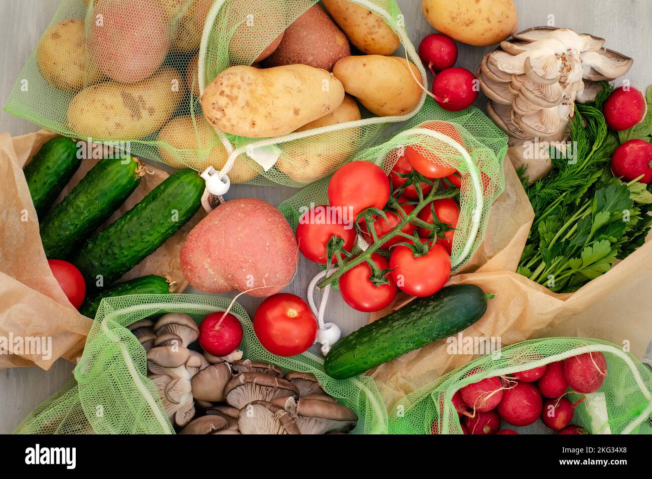 Vegetables in reusable net bags on grey wooden background, top view ...
