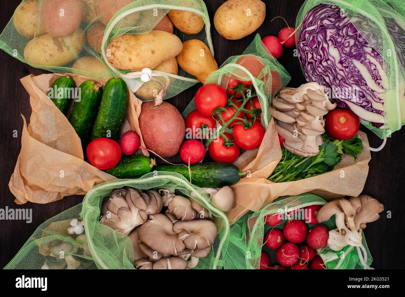 Vegetables in reusable net bags on grey wooden background, top view ...