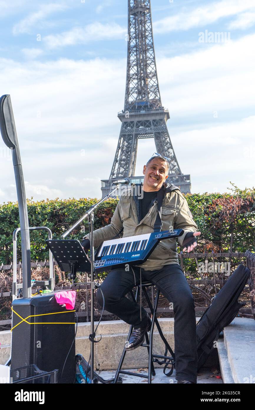 A vertical of a male musician with his instrument with the Eiffel Tower ...