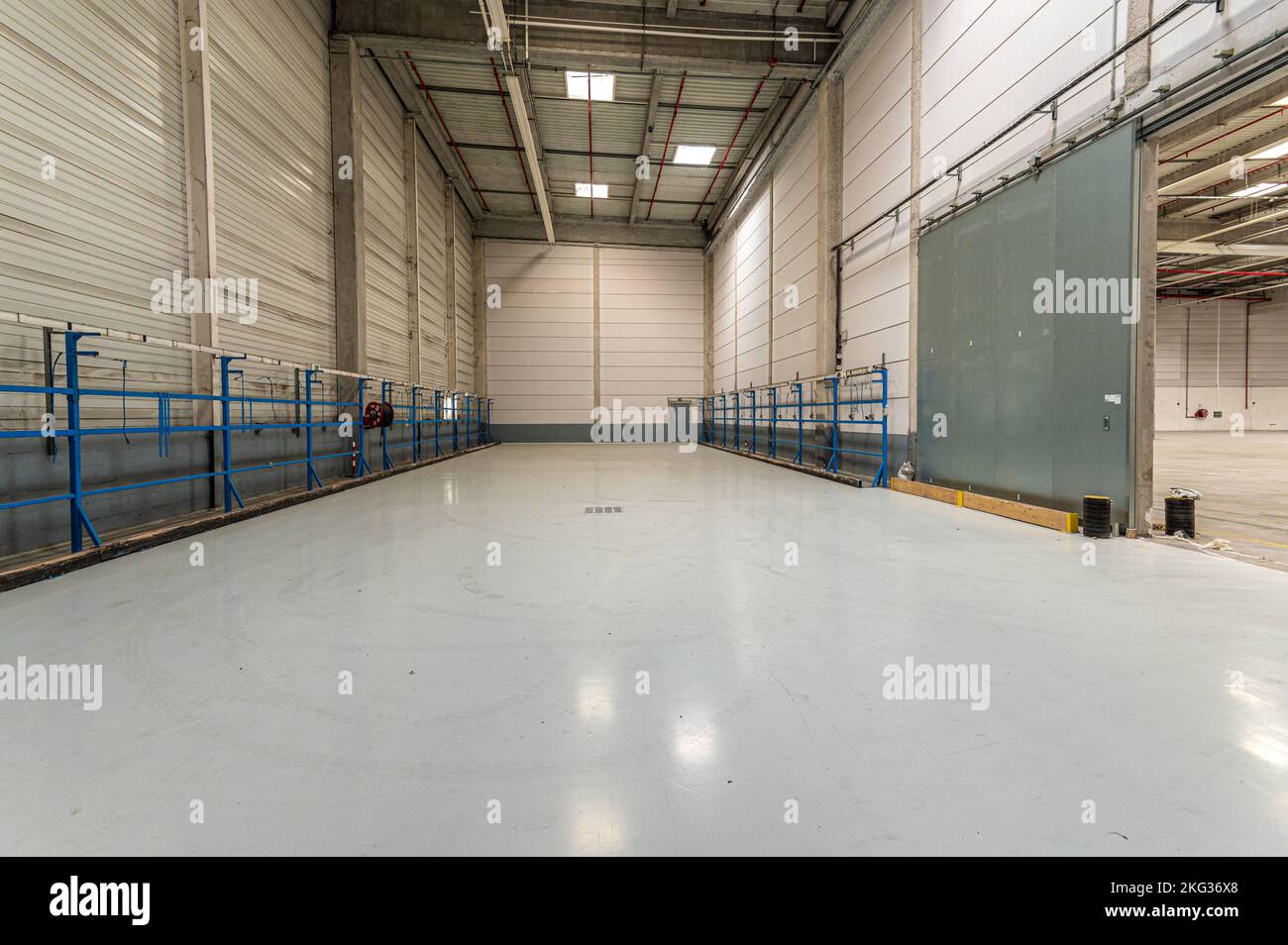 Low angle shot of empty stockroom featuring entrance shutter door and ...