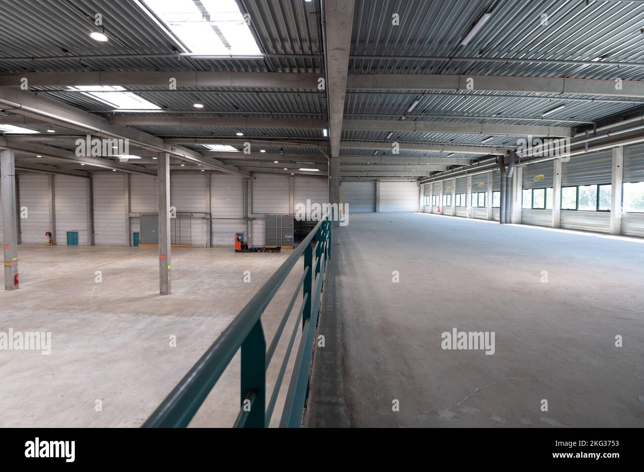 Shot of empty storehouse surrounded with shutter walls under steel roof ...