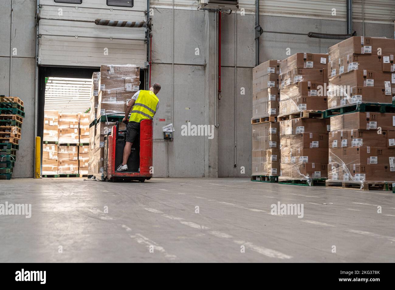 Shot of electric forklift truck male operator lifts pallet with ...