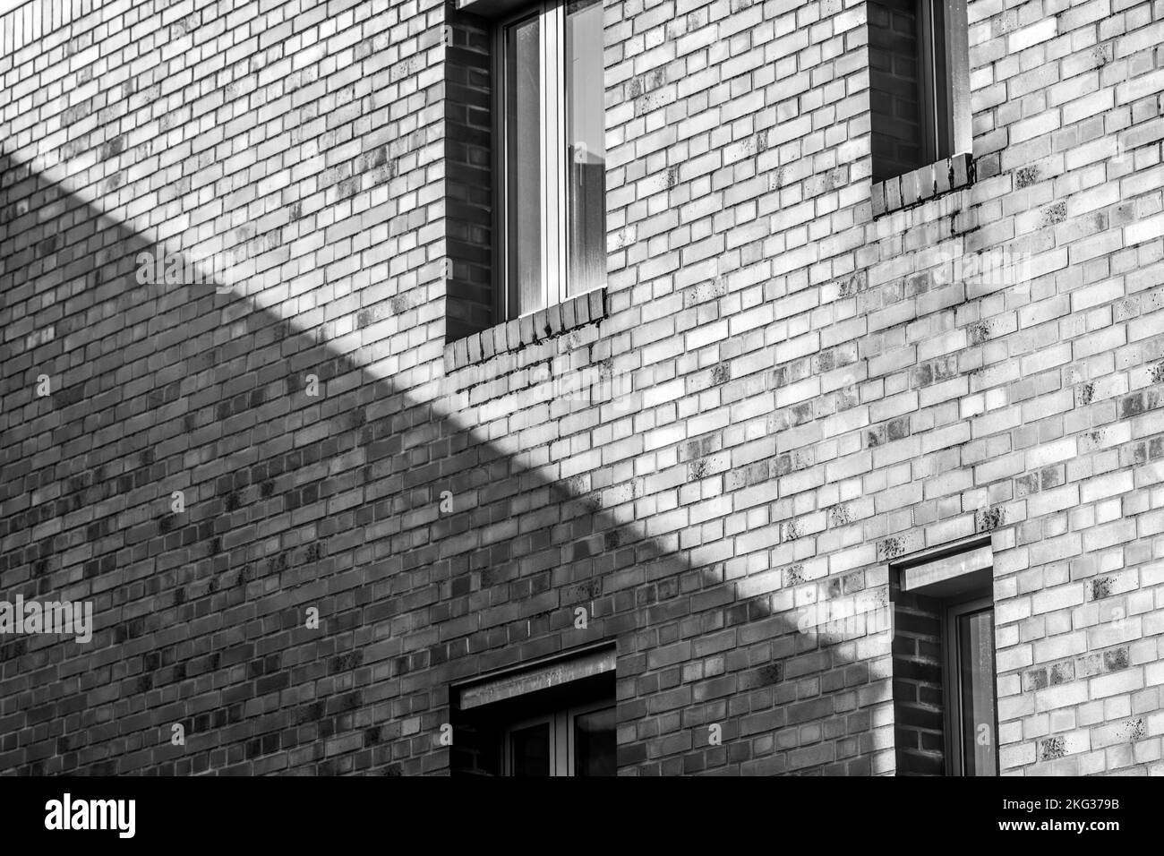 The low-angle grayscale shot of a brick-built building's facade under ...