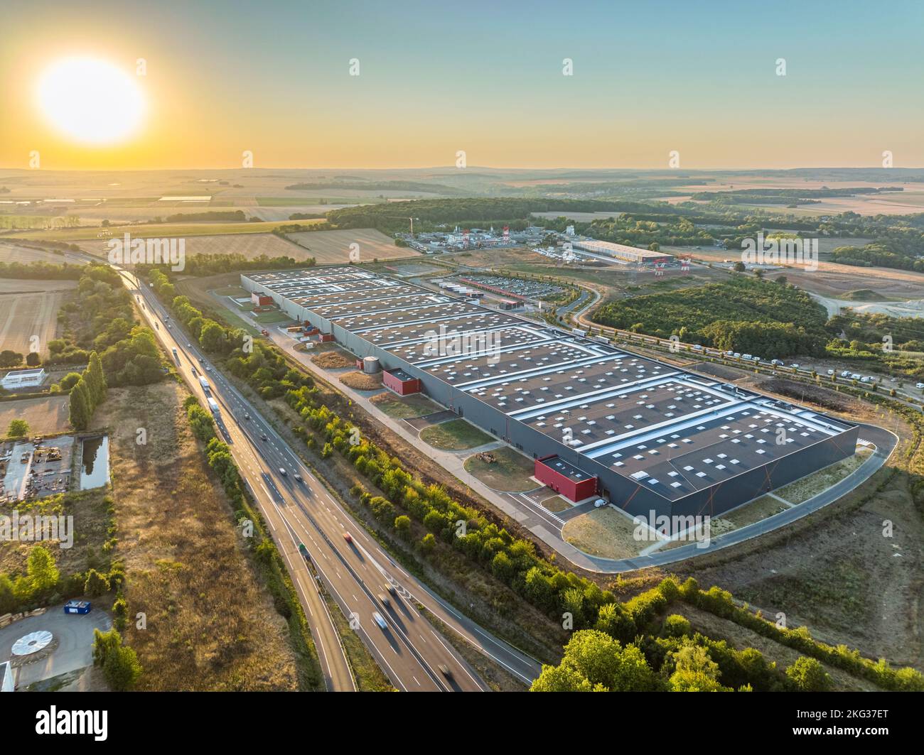 Aerial shot of warehouse property surrounded with lush greenery and ...