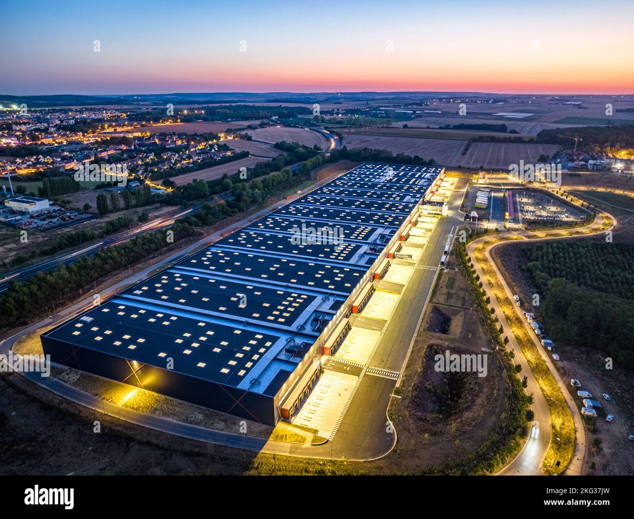 Aerial view of a warehouse of goods near freeway surrounded by lush ...