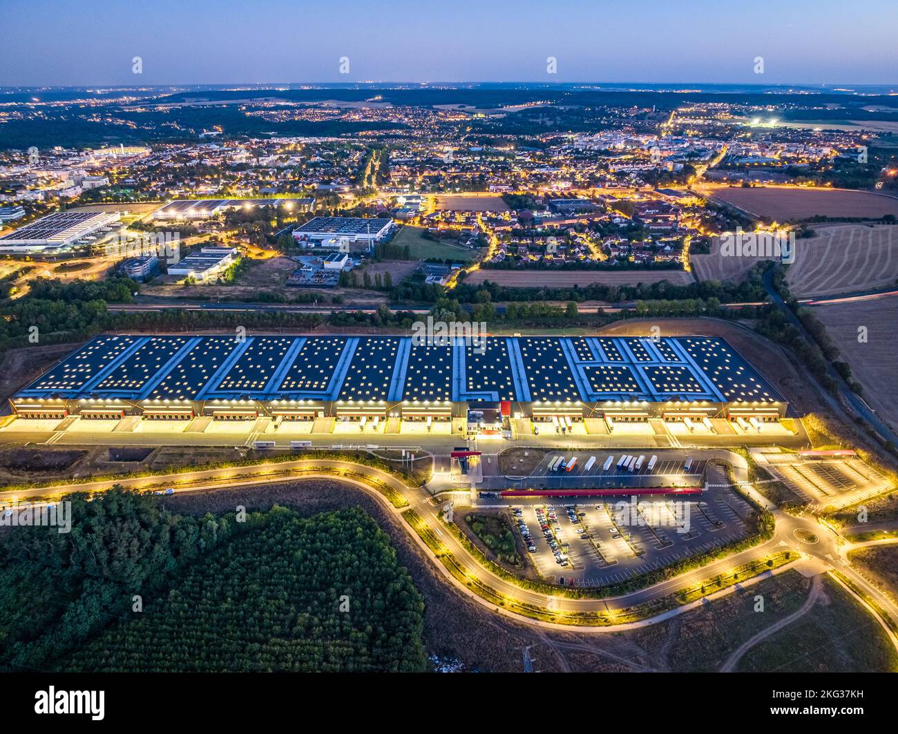 Aerial top view of a warehouse of inventory surrounded by lush greenery ...