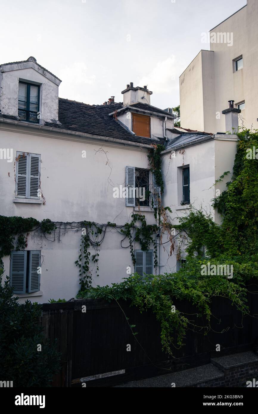 An old traditional house with wooden fence covered with climbing green ...