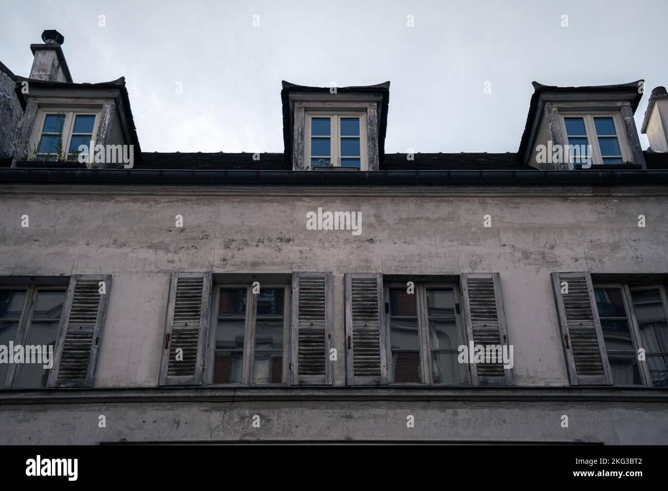 A low angle shot of an old building with three dormer window under ...