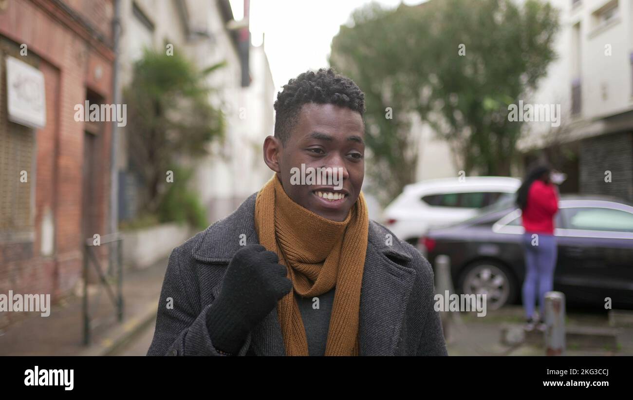 Happy black man celebrating success while walking outside in street ...