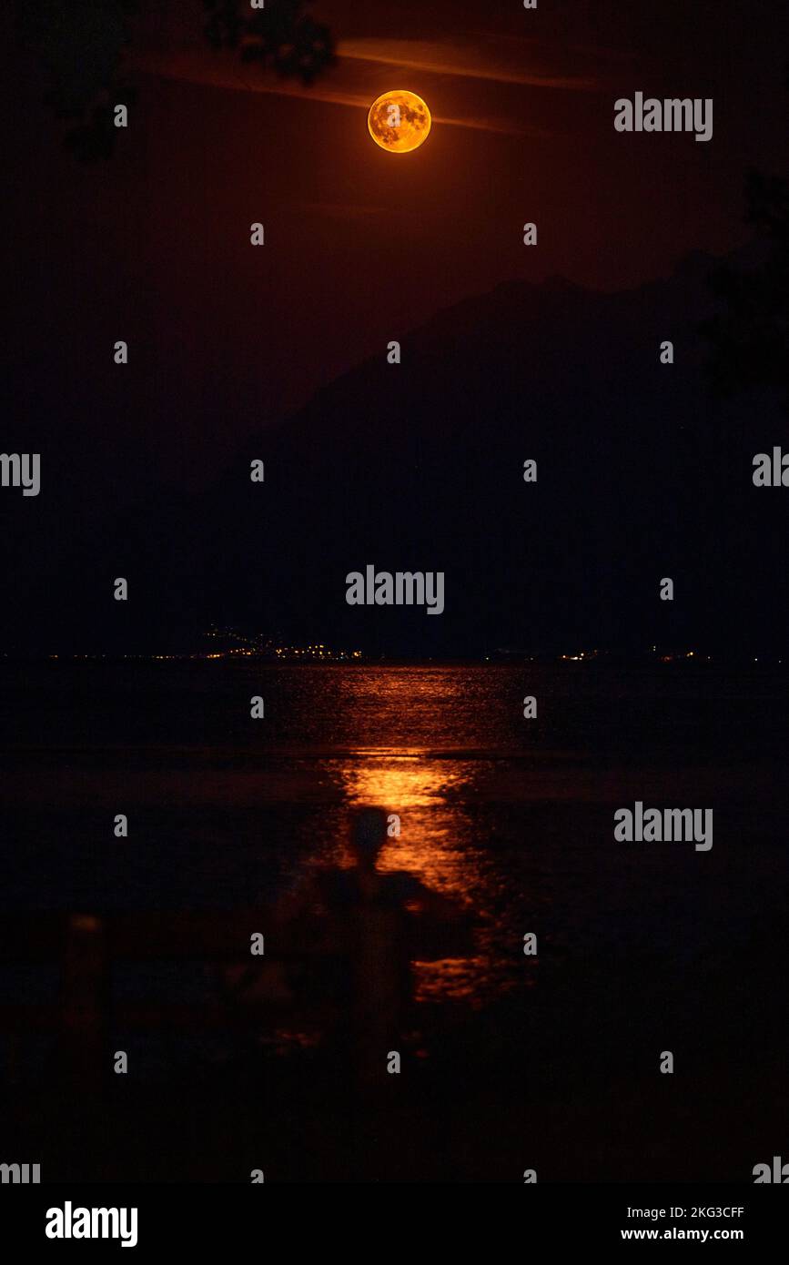 A vertical shot the Blood Moon reflecting on the sea surface at night ...