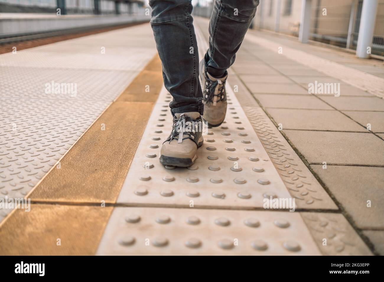 Man jeans and sport sneaker shoes walking at the railway station ...
