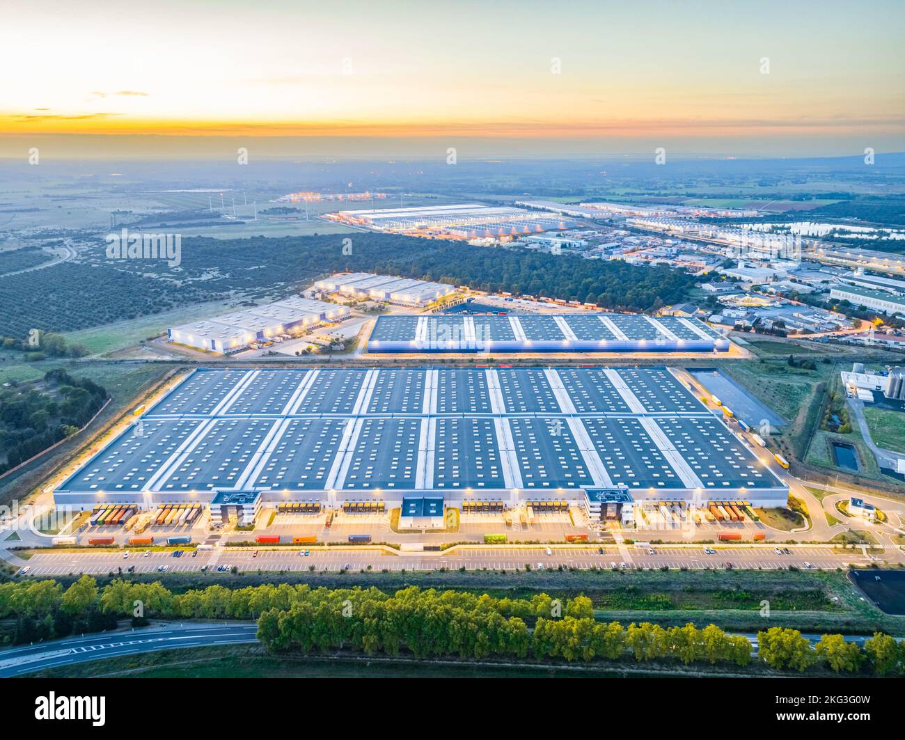Aerial morning view of large warehouse surrounded by greenery and ...