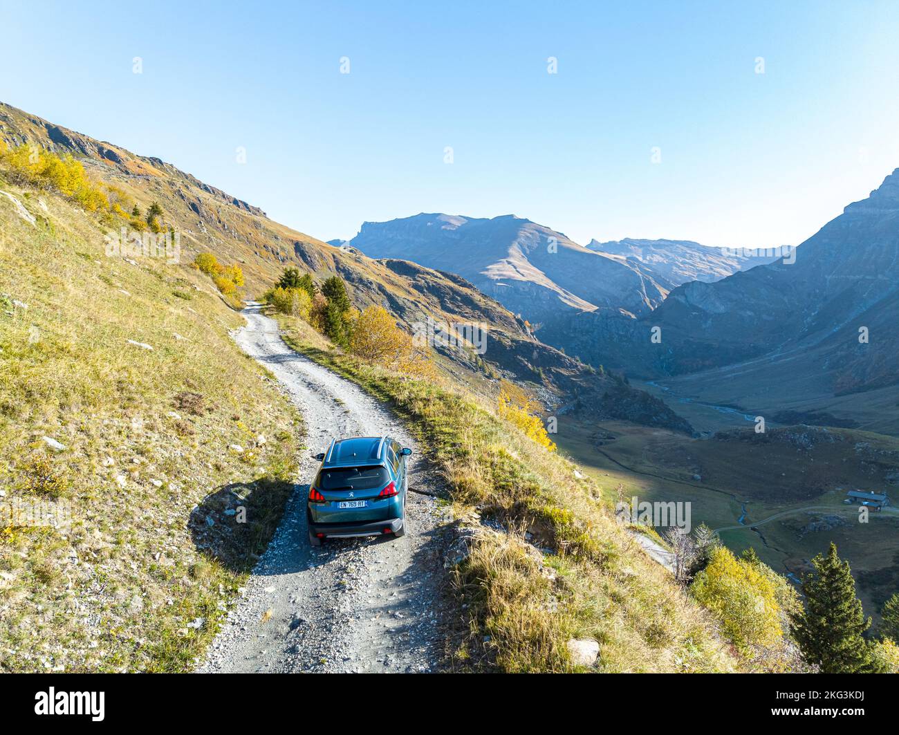 A car passing from risky path on single mountain road over the hill in ...